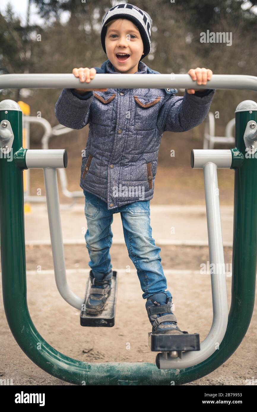 Boy exercising at an outdoor gym in the park Stock Photo - Alamy