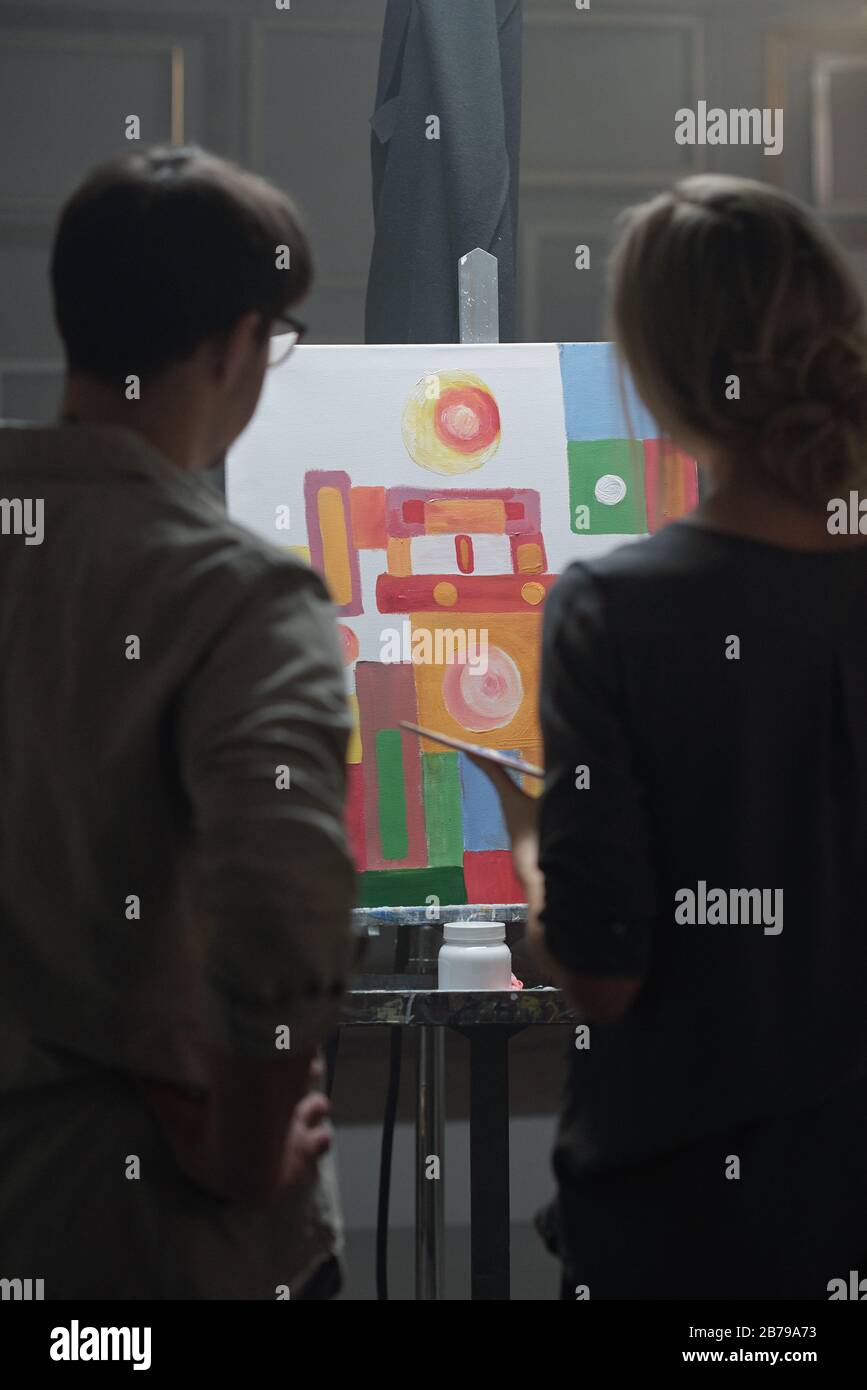 Young female student of school of arts and her teacher standing in ...