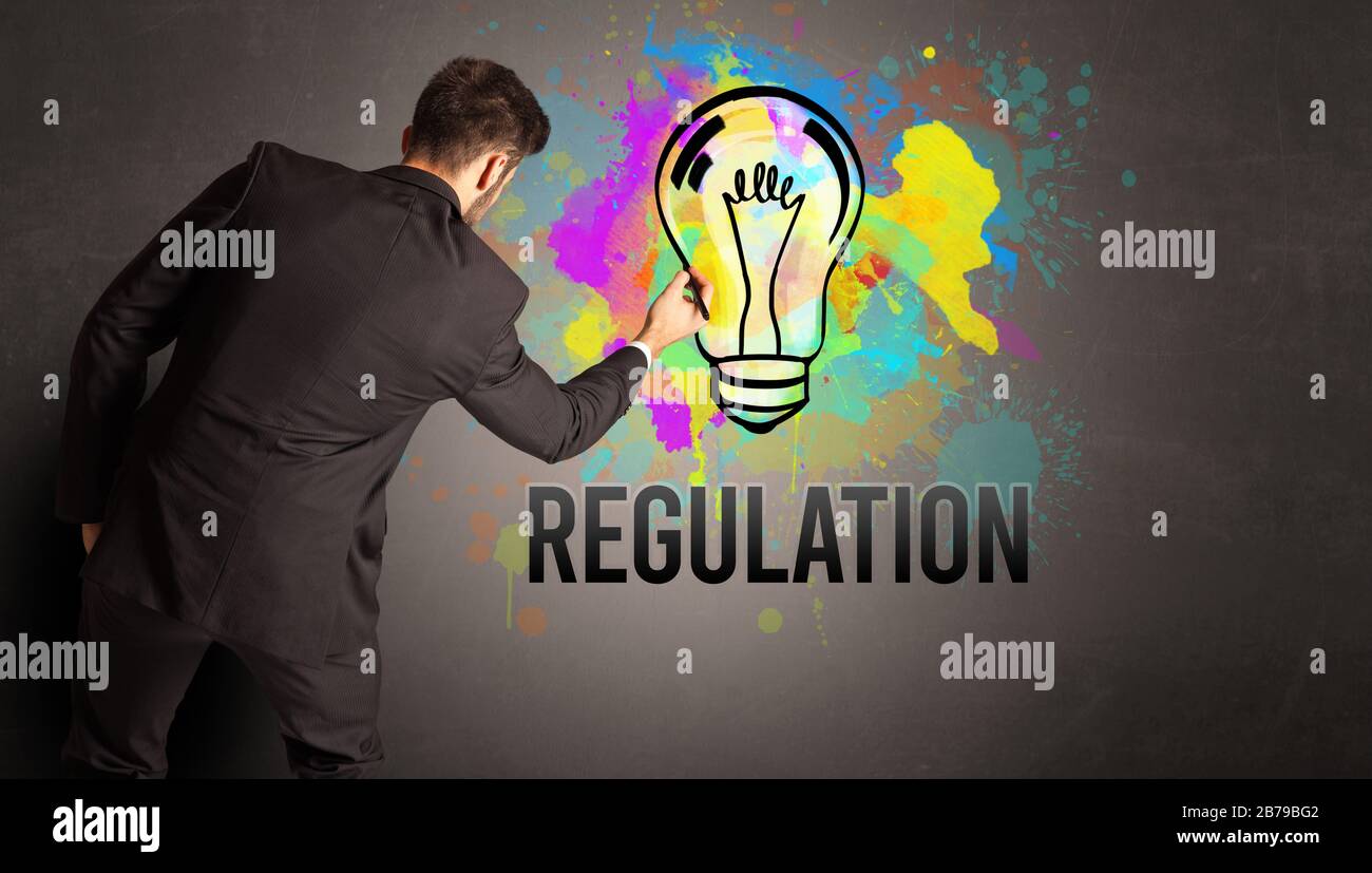 businessman drawing colorful light bulb with REGULATION inscription on ...