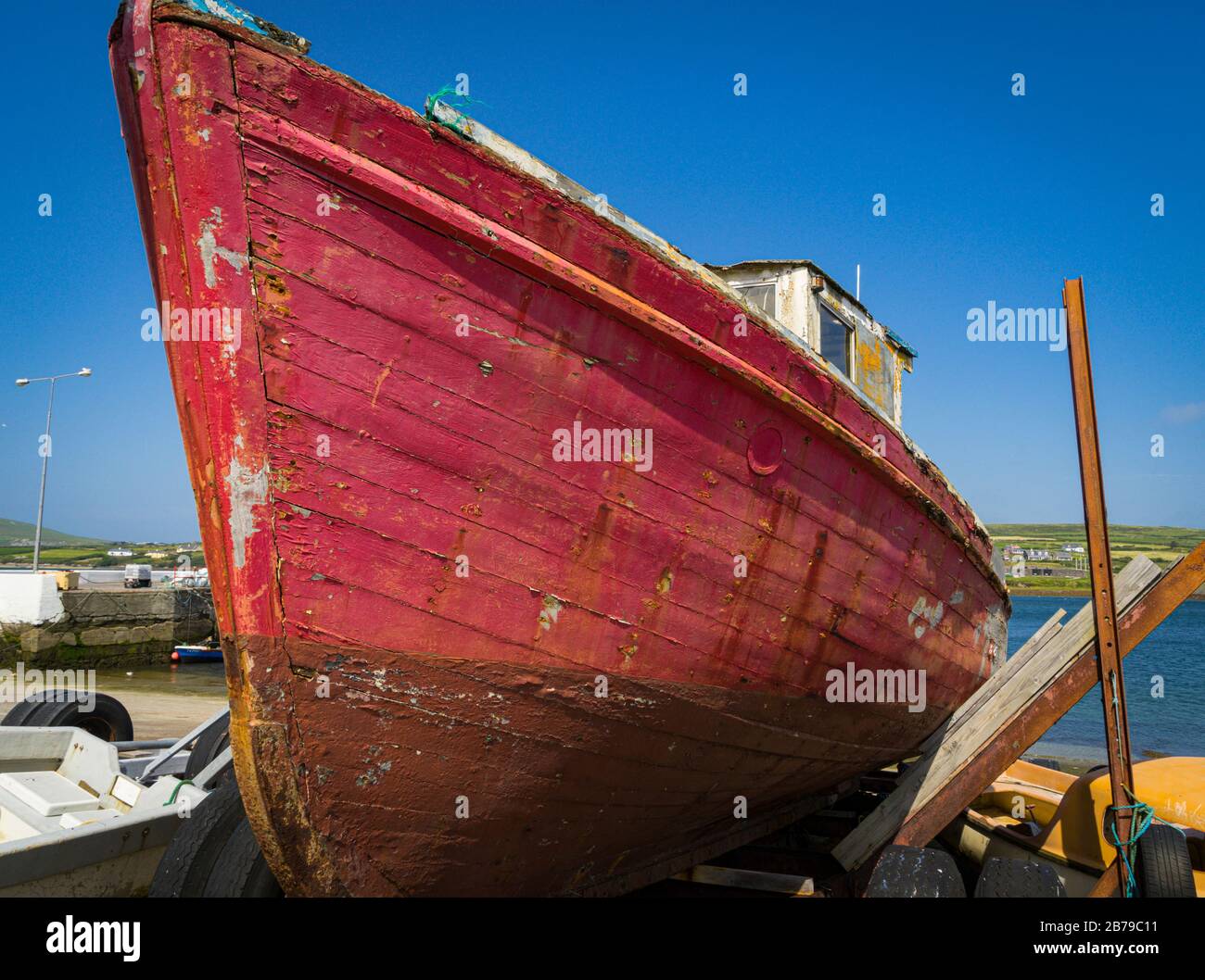 Old red colored boat photographed wide angle in the harbor of the Irish ...