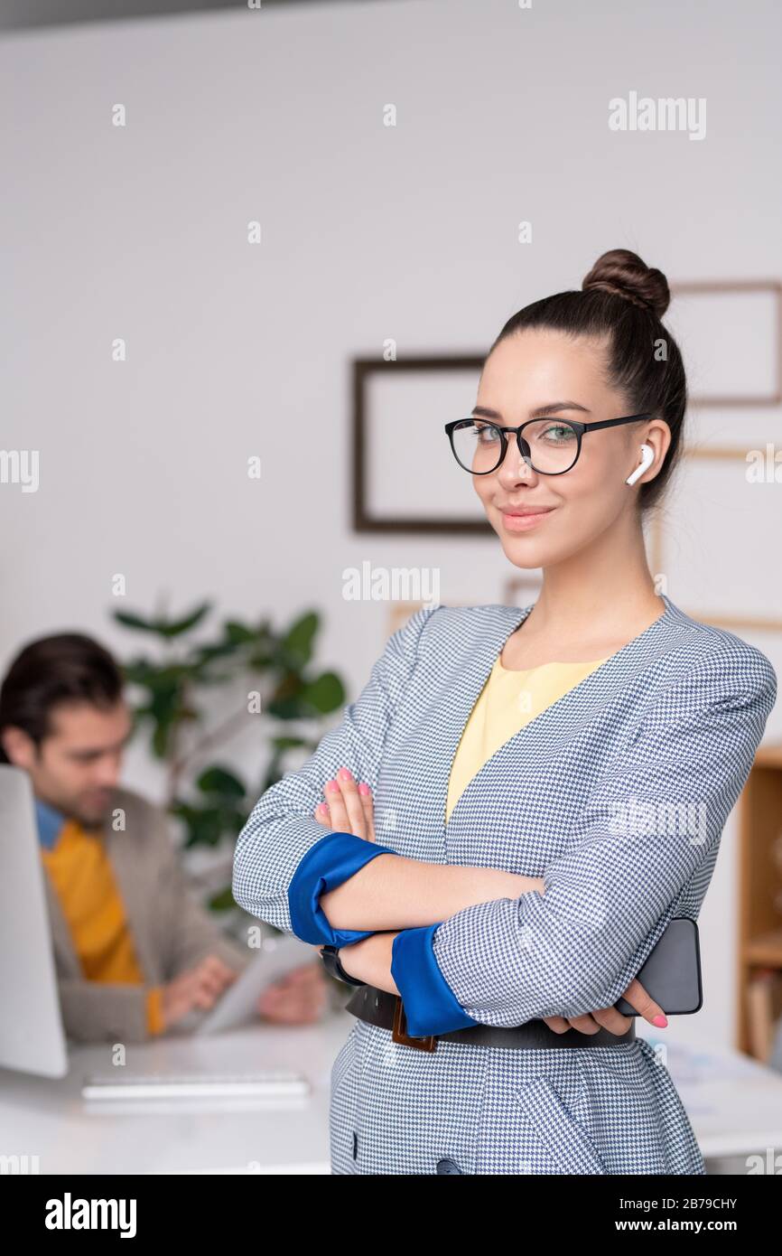 Pretty young smiling office manager or secretary in formalwear and ...