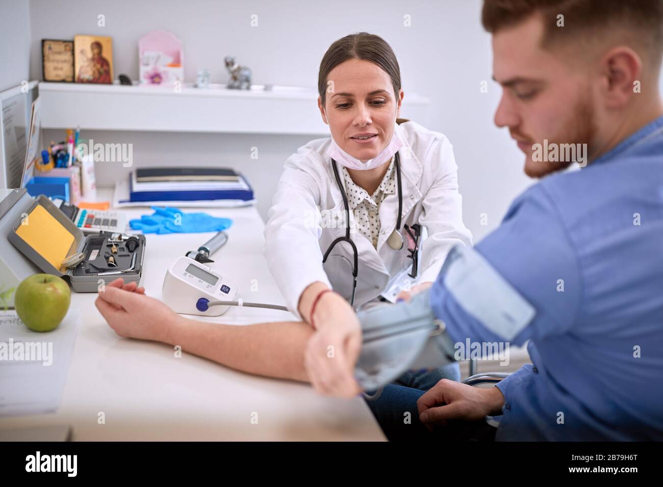 Female doctor putting cuff on patients arm Stock Photo - Alamy