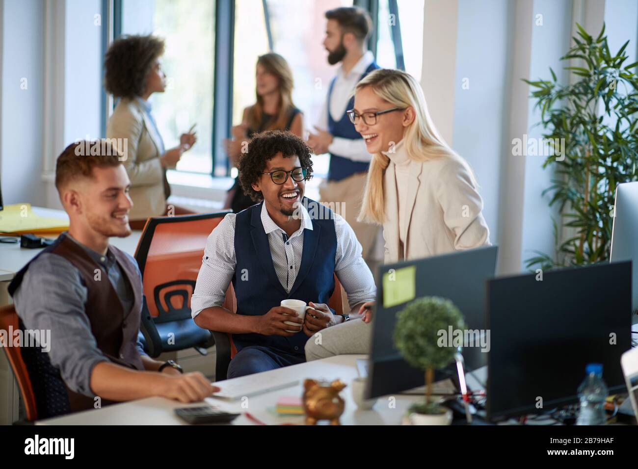 Business people having coffee break at work. Cheerful young colleagues ...