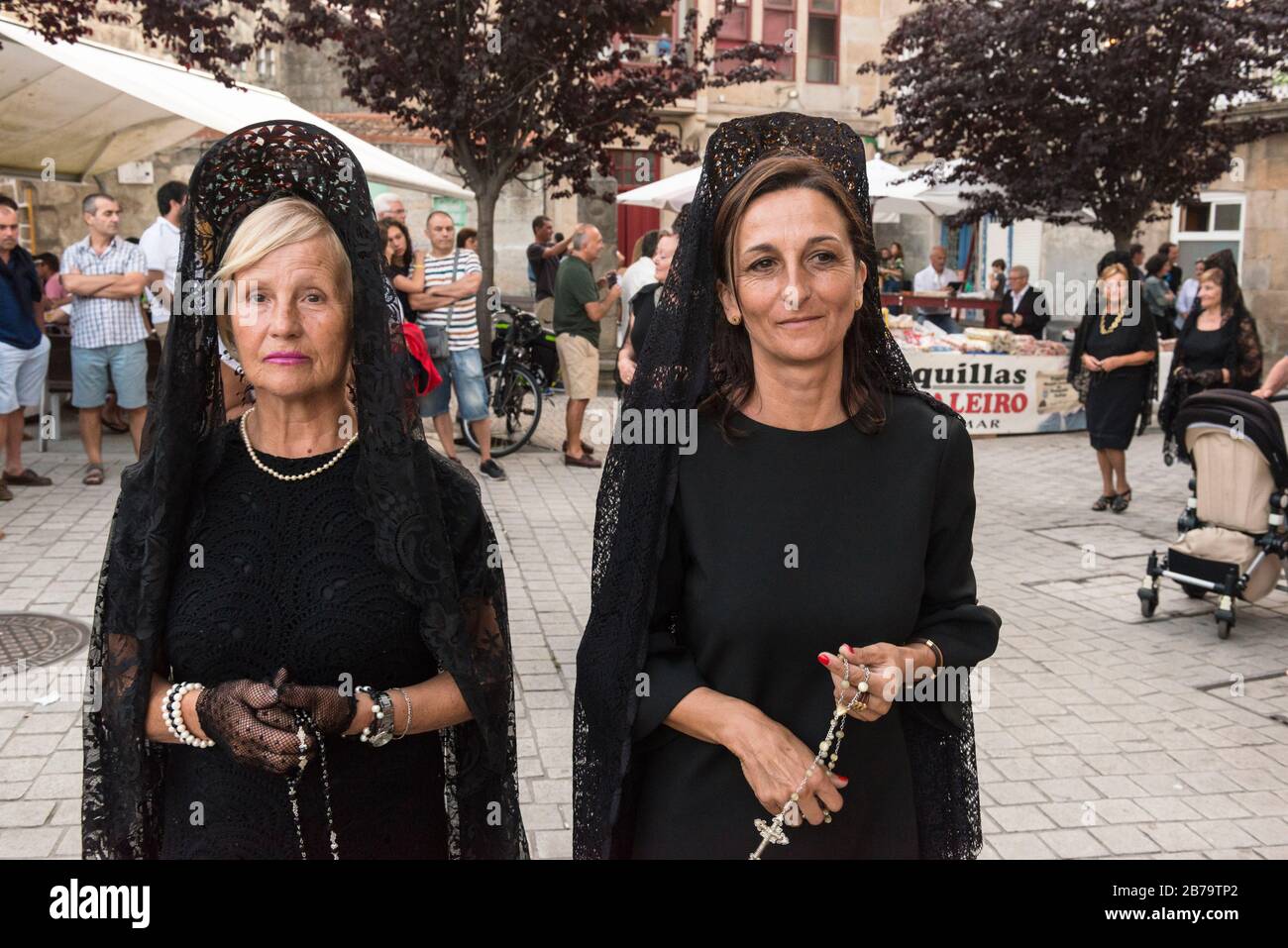 Women wearing traditional black dresses and mantilla (lace veils), part ...