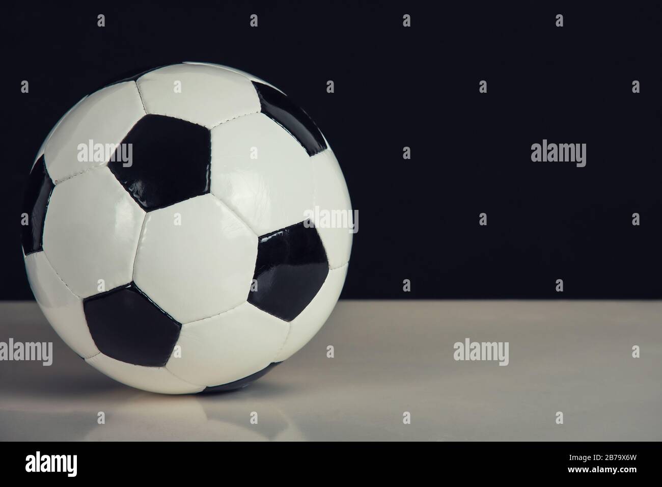 Classic football ball, black and white pattern, isolated on the table ...