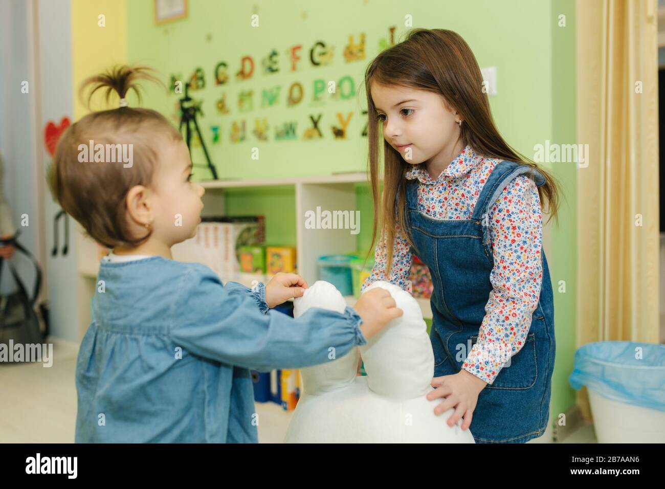 Little girl help little baby in nursery. Cute children play Stock Photo ...