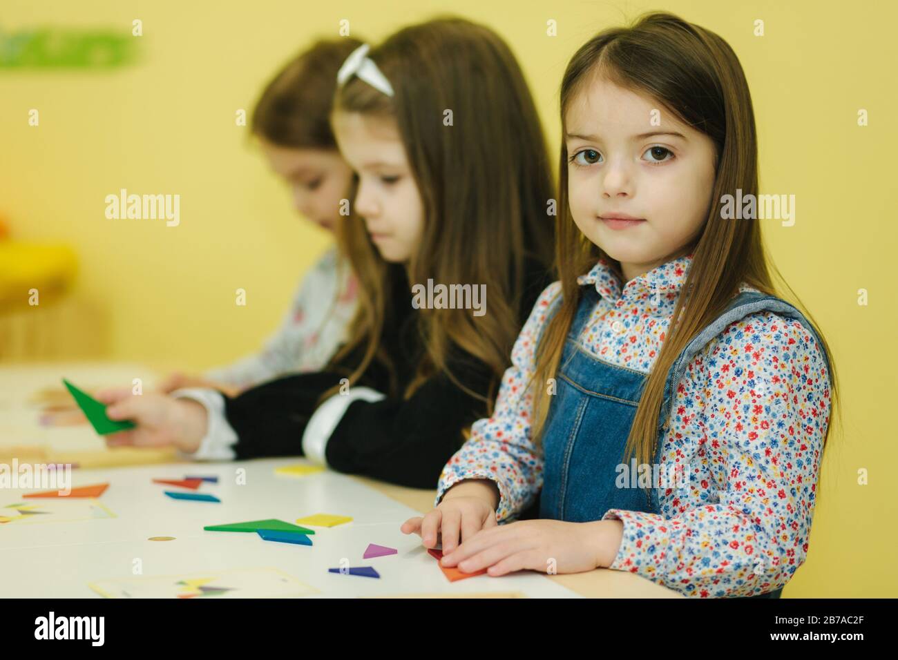 Children play with different figures on the table. Girls and boys in ...