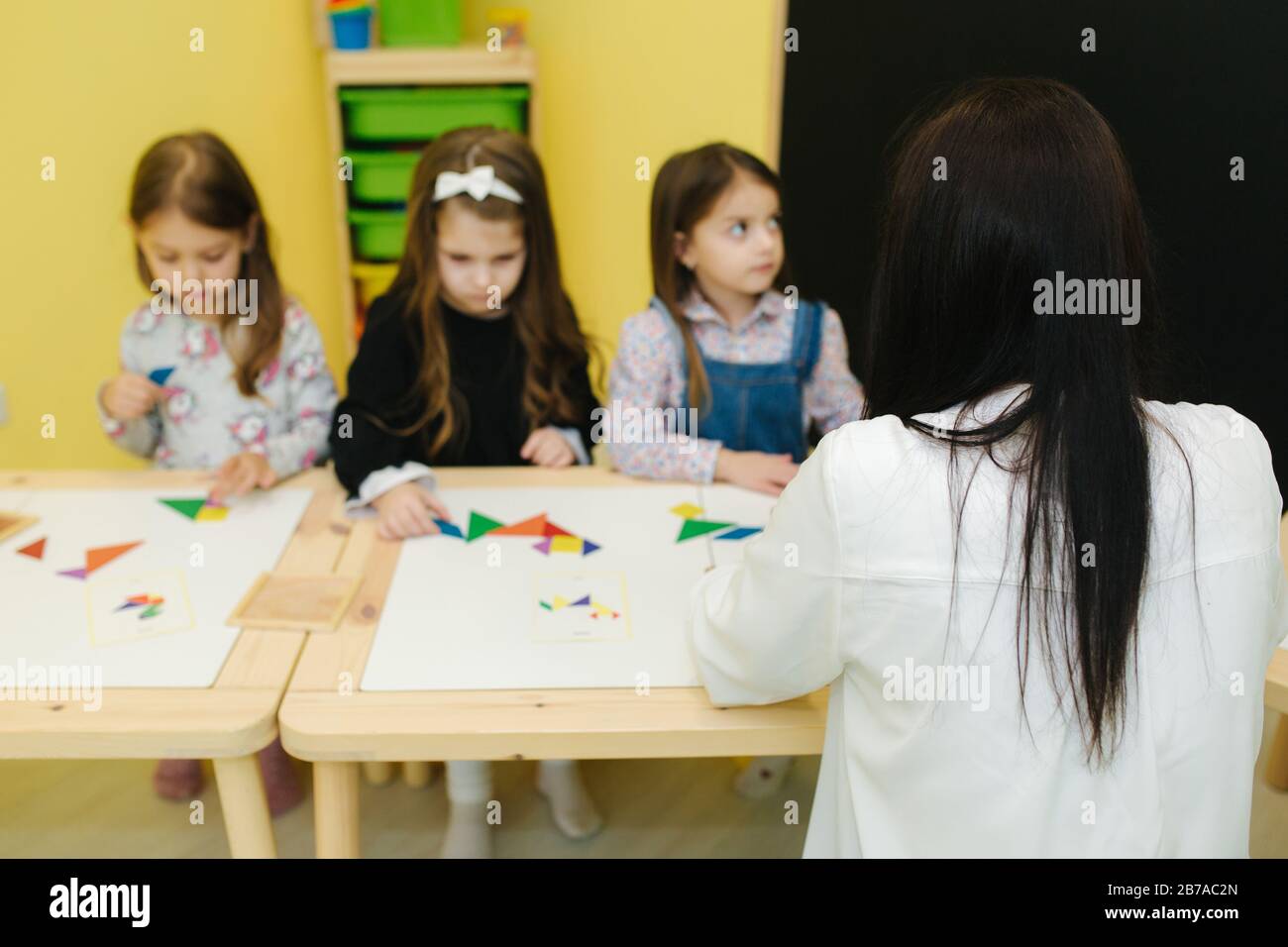 Children play with different figures on the table. Girls and boys in ...