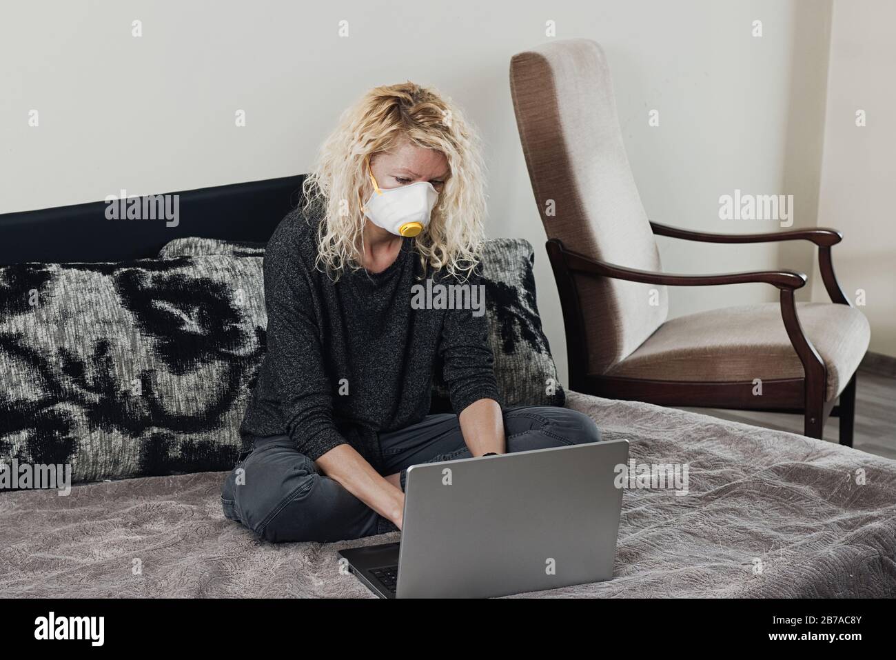 Woman in quarantine for Coronavirus wearing protective mask and smart ...
