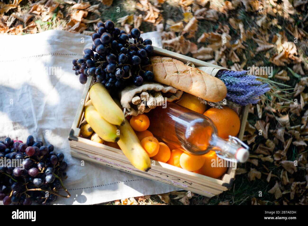 autumn picnic wooden box with fruits-grapes, bananas, Oranges and ...