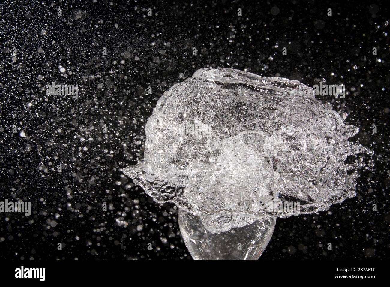 balloon full of water exploding with black background Stock Photo - Alamy