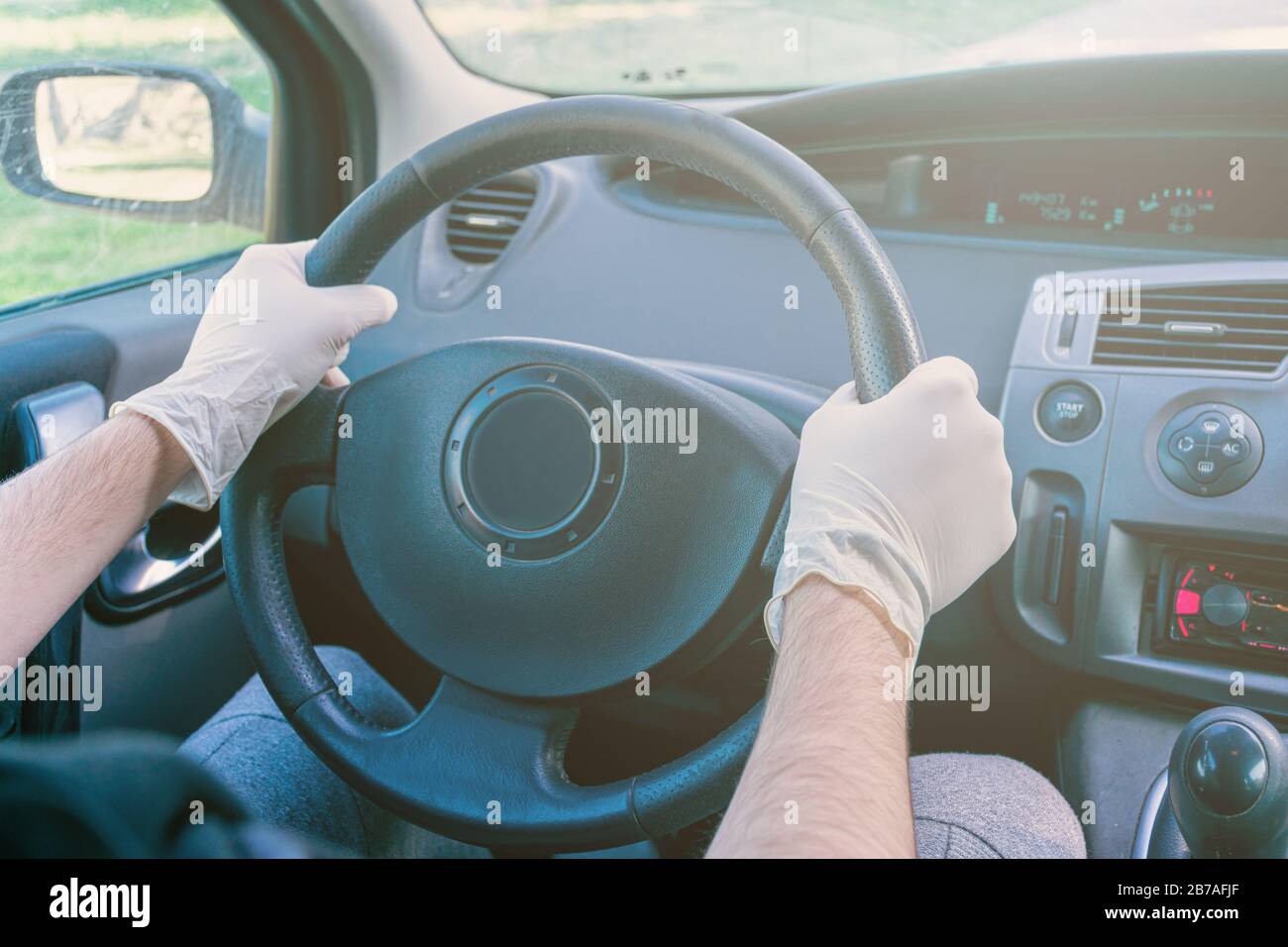 Hands holding the steering wheel of a car while driving with latex ...