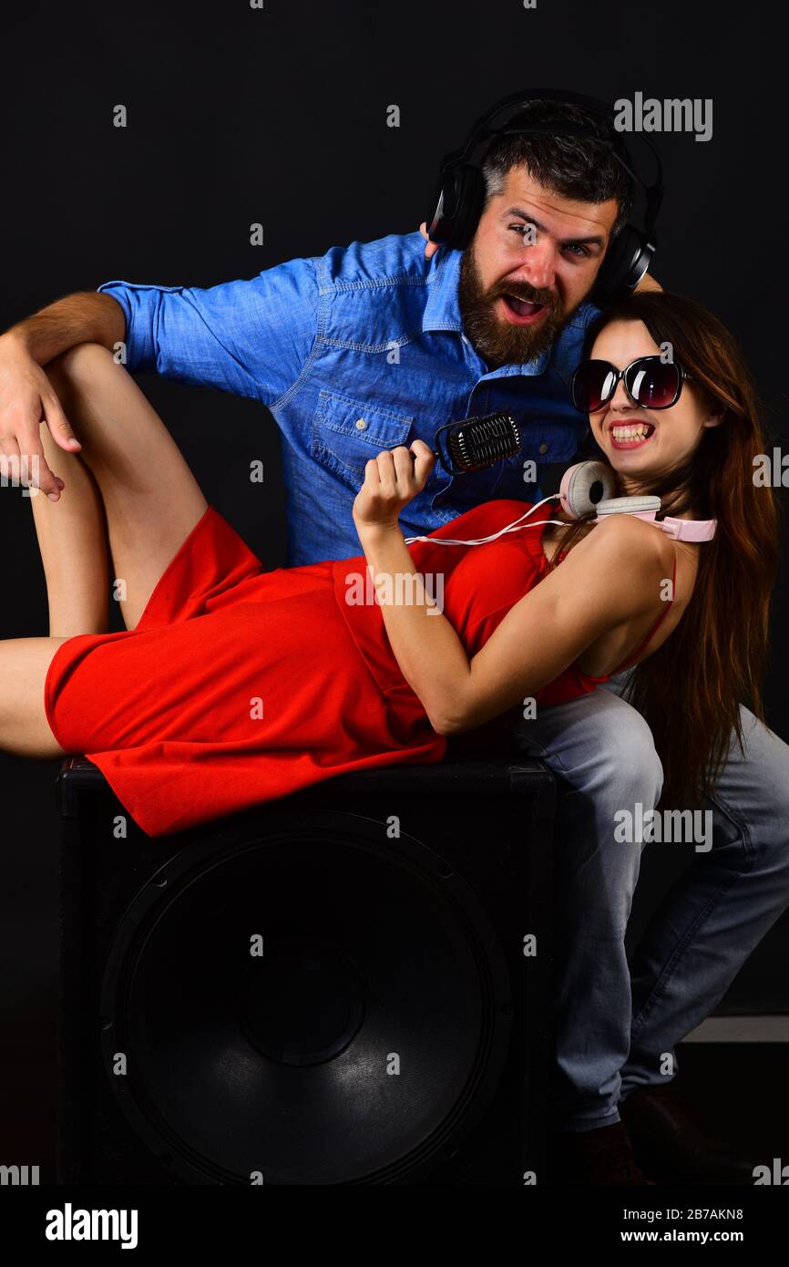 Couple in love wears headphones and holds microphone. Music fans with ...