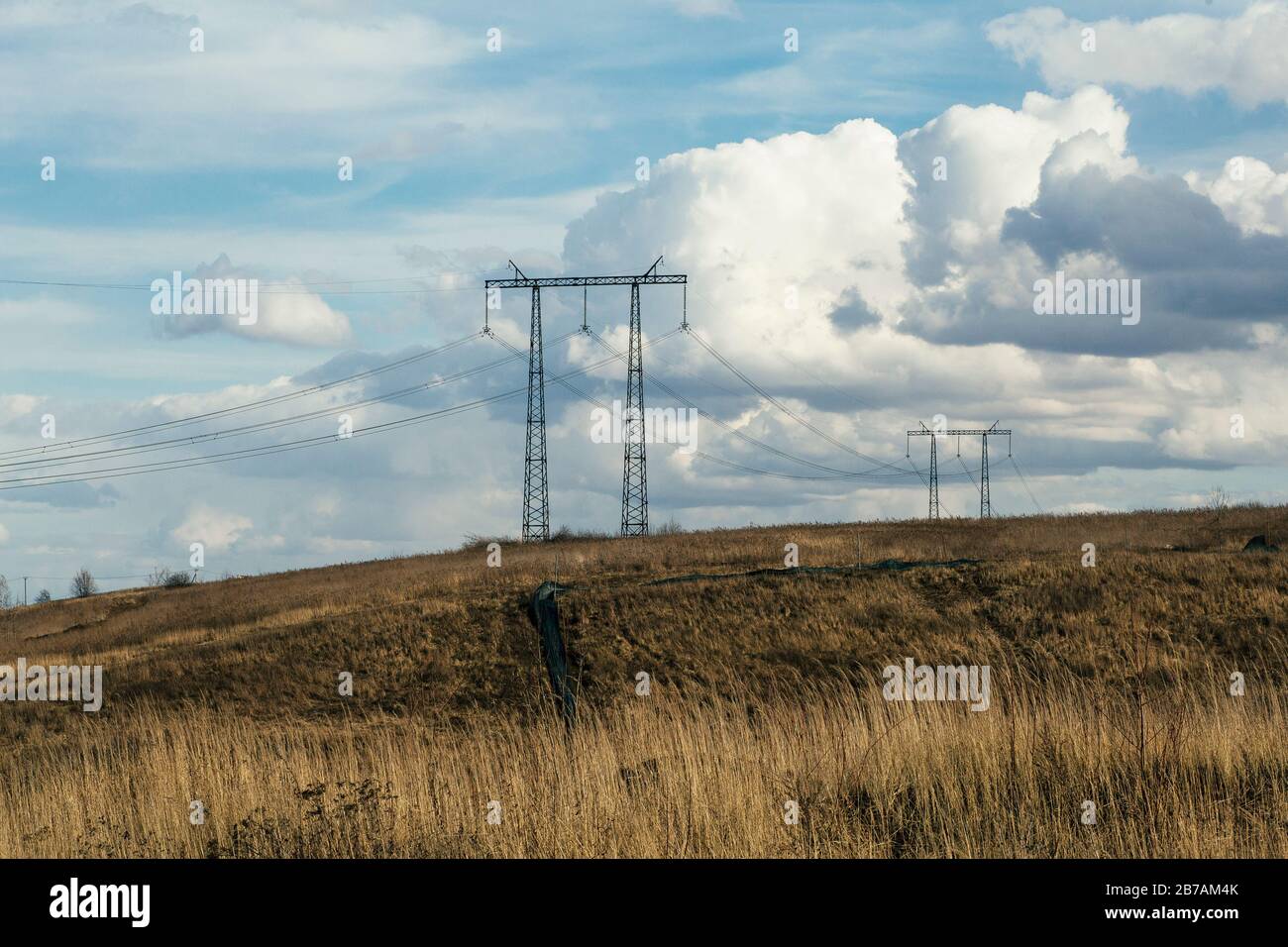 Power lines in the field. Power lines in a spring field against a blue ...