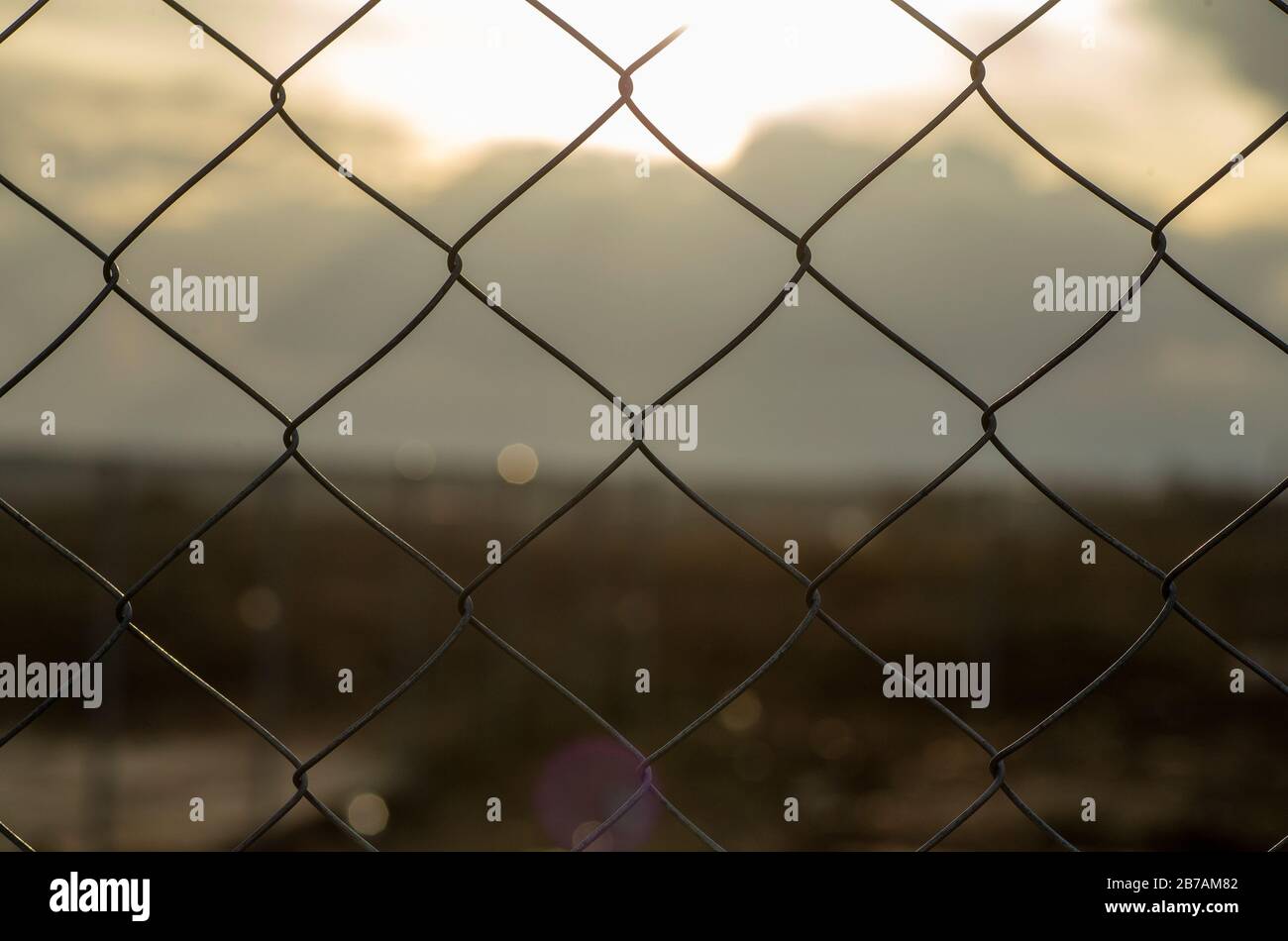 Restricted area concept. A metal mesh fence enclosing a restricted area ...