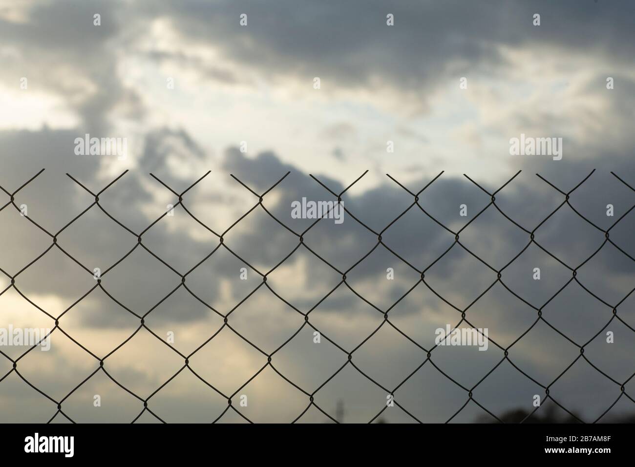 Restricted area concept. A metal mesh fence enclosing a restricted area ...