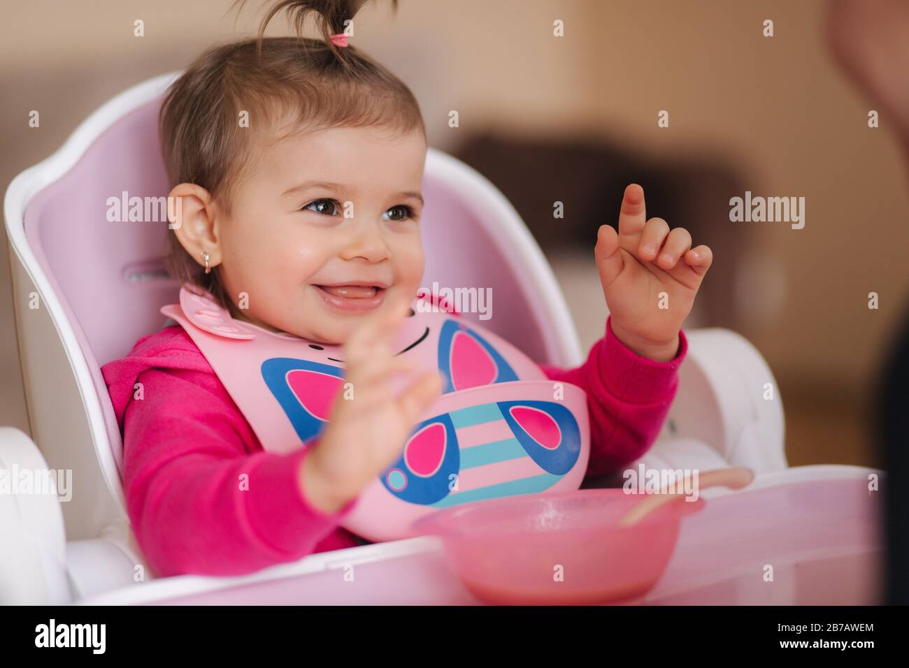 Little cute baby girl are eating in hight chair. Portrait of little ...