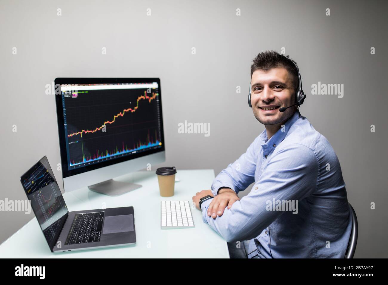 Side view of male trader using multiple computer screens while ...