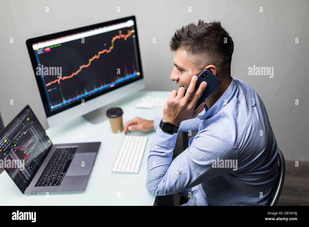 Agent trader man talking at telephone and checking business stock data ...