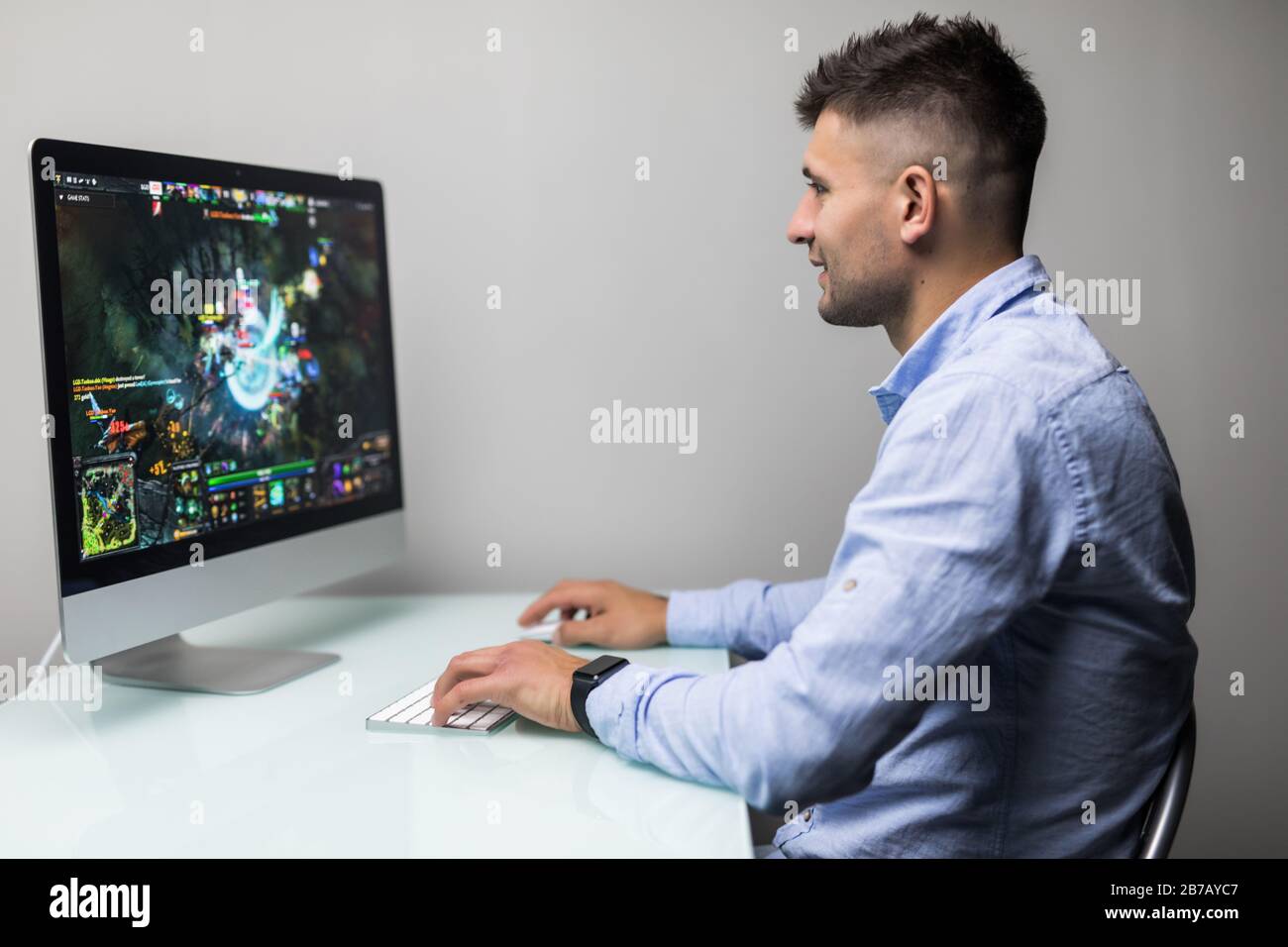 Young computer man gamer concentrating on his game at computer monitor ...