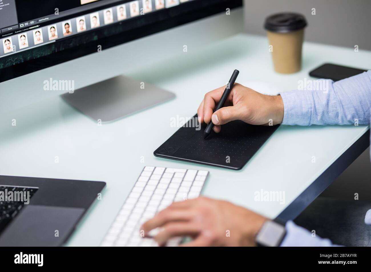 Hand of male designer work at his desk using stylus and digital ...