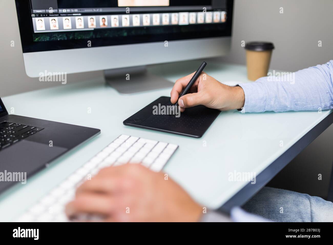 Hand of man designer working at his desk using stylus and digital ...
