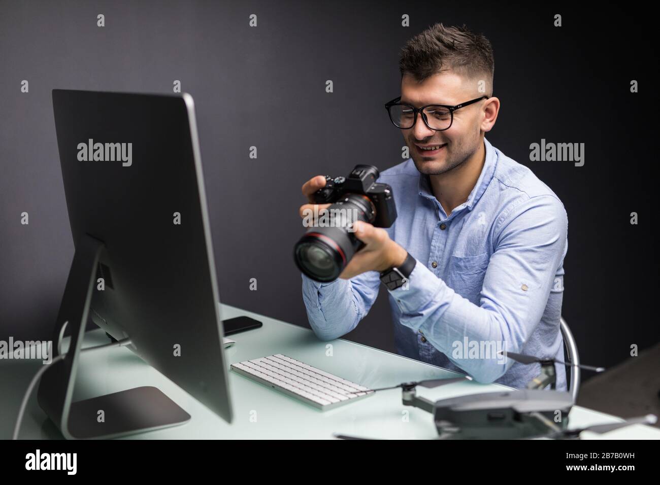 Photographer in office working on desktop computer Stock Photo - Alamy
