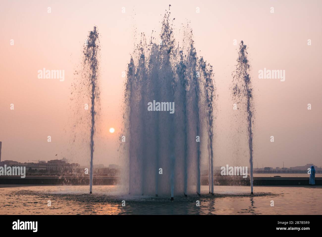 The sun sets behind a water fountain in front of the Museum of Islamic ...