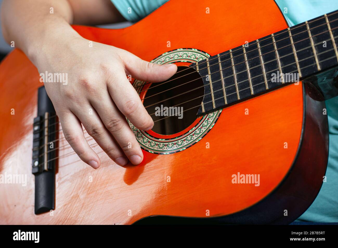 guy playing an acoustic six-string guitar. learning to play a musical ...