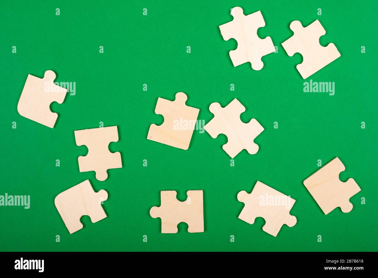 collect puzzles. puzzle pieces scattered on a green background Stock ...