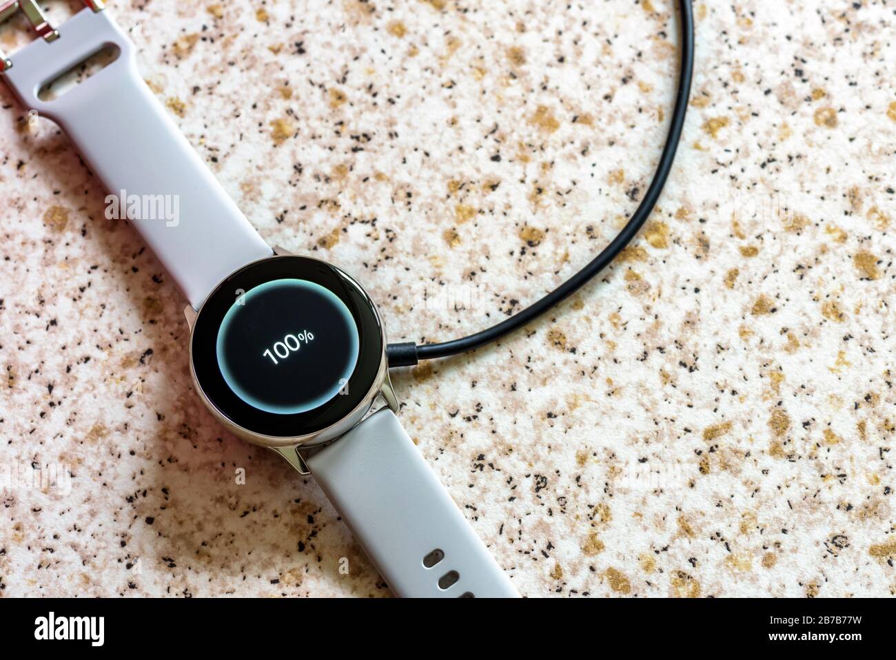 smart watch wireless charging on charging pad on kitchen worktop table ...