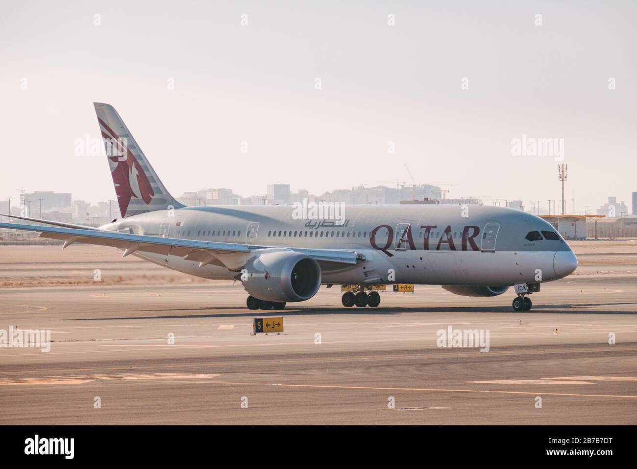 A Qatar Airways Boeing 787 taxis to parking on a hazy summer day at ...