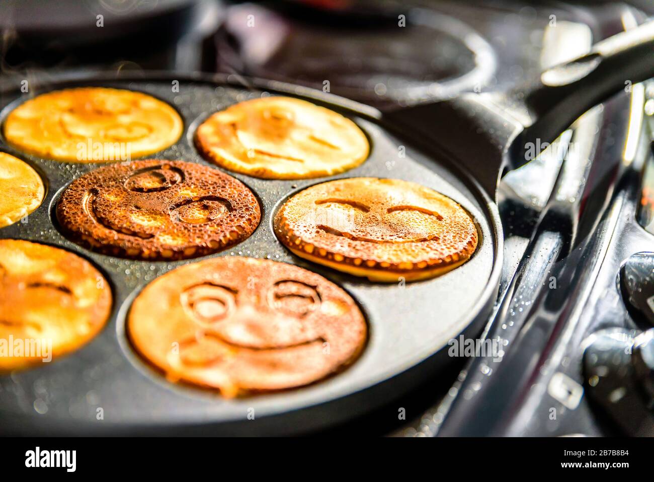 pancake frying pan with smile face pancake cooking on cooker in kitchen ...