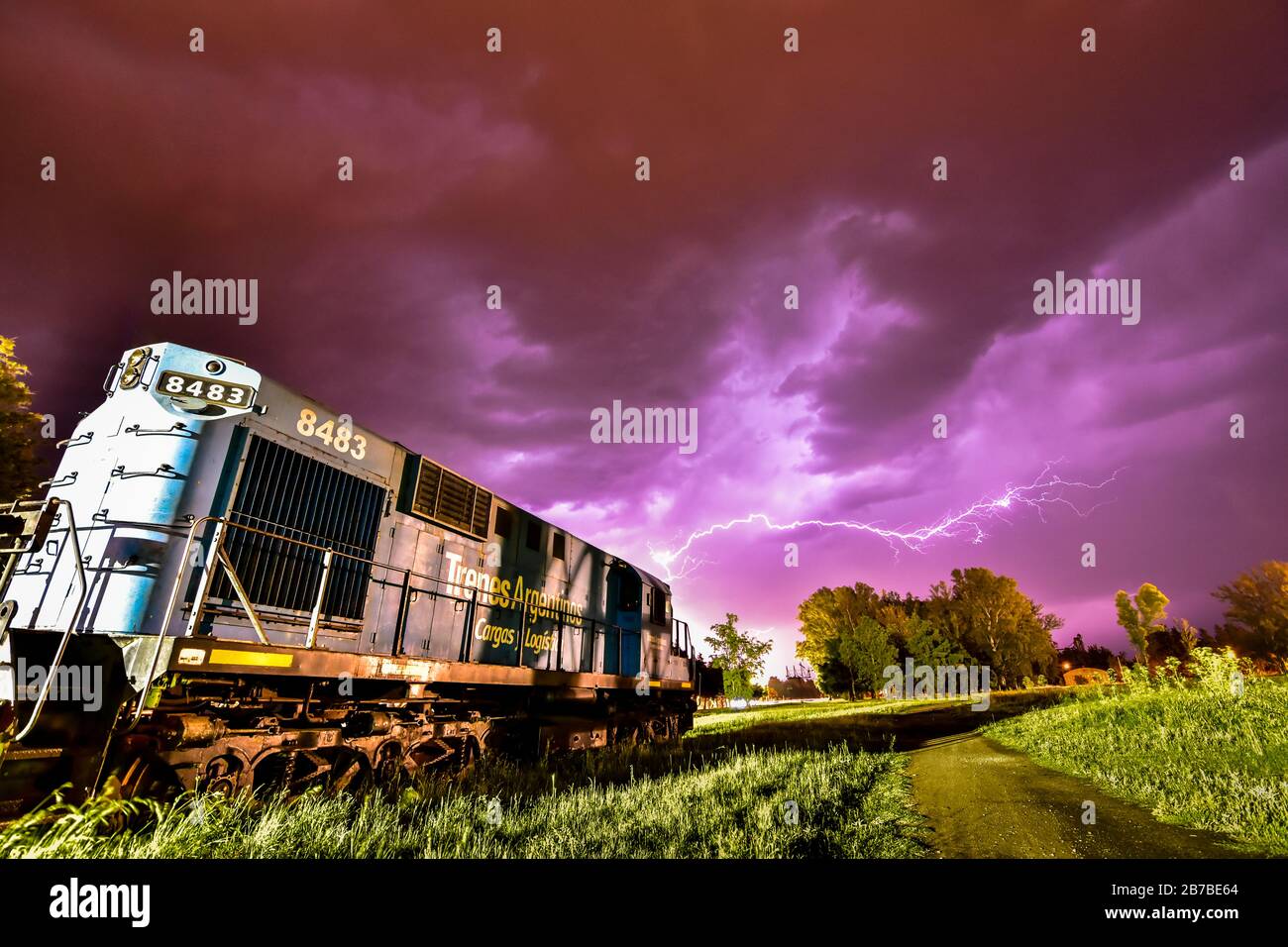 Scene view of a locomotive beneath a thunderstorm during summer night ...