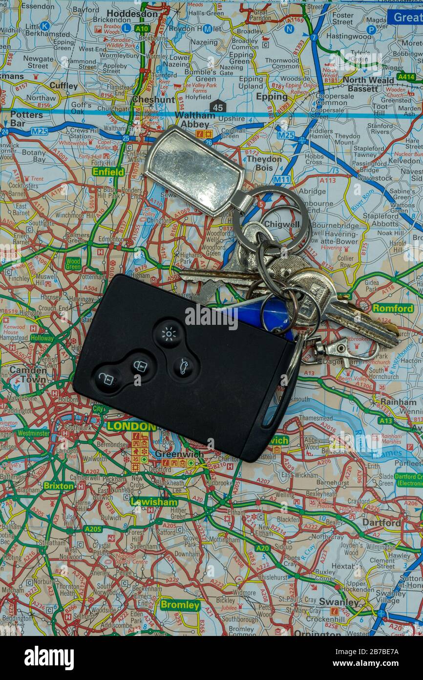 A set of keys and a car key laid on top of a road map of London Stock ...