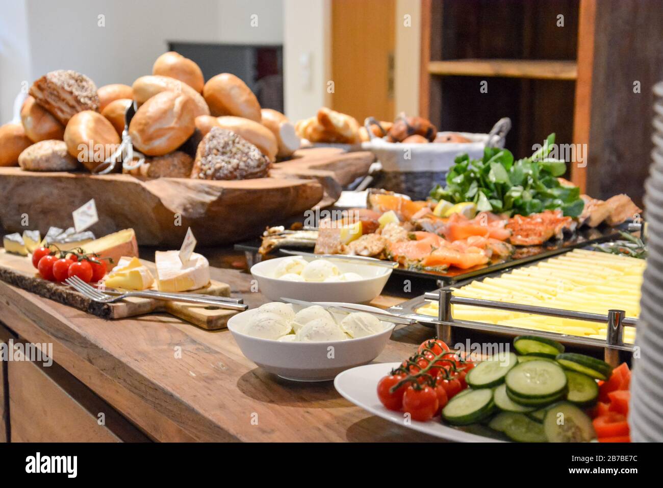 A breakfast buffet with rolls, cheese and several vegetables Stock ...