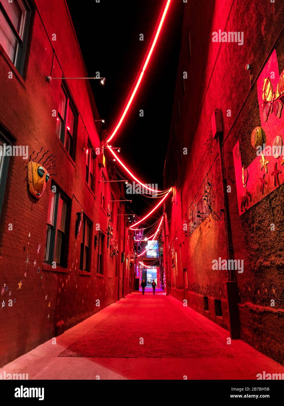 Strung red lights down an urban city alleyway Stock Photo - Alamy