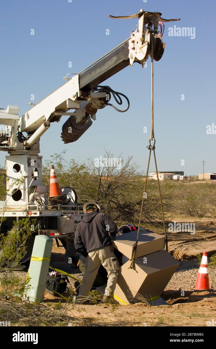 Taken in 2010. Two utility workmen using a crane to aid them in the ...