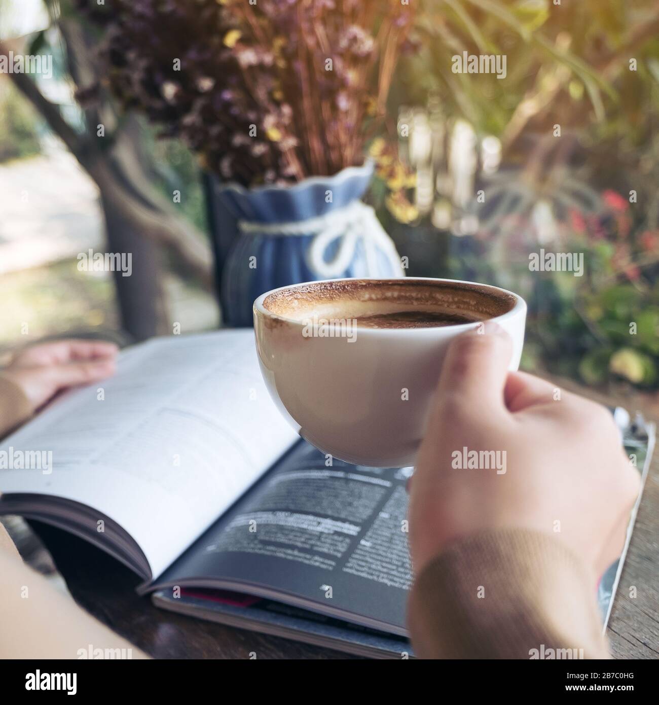 Closeup image of a woman reading book and drinking coffee in cafe Stock ...