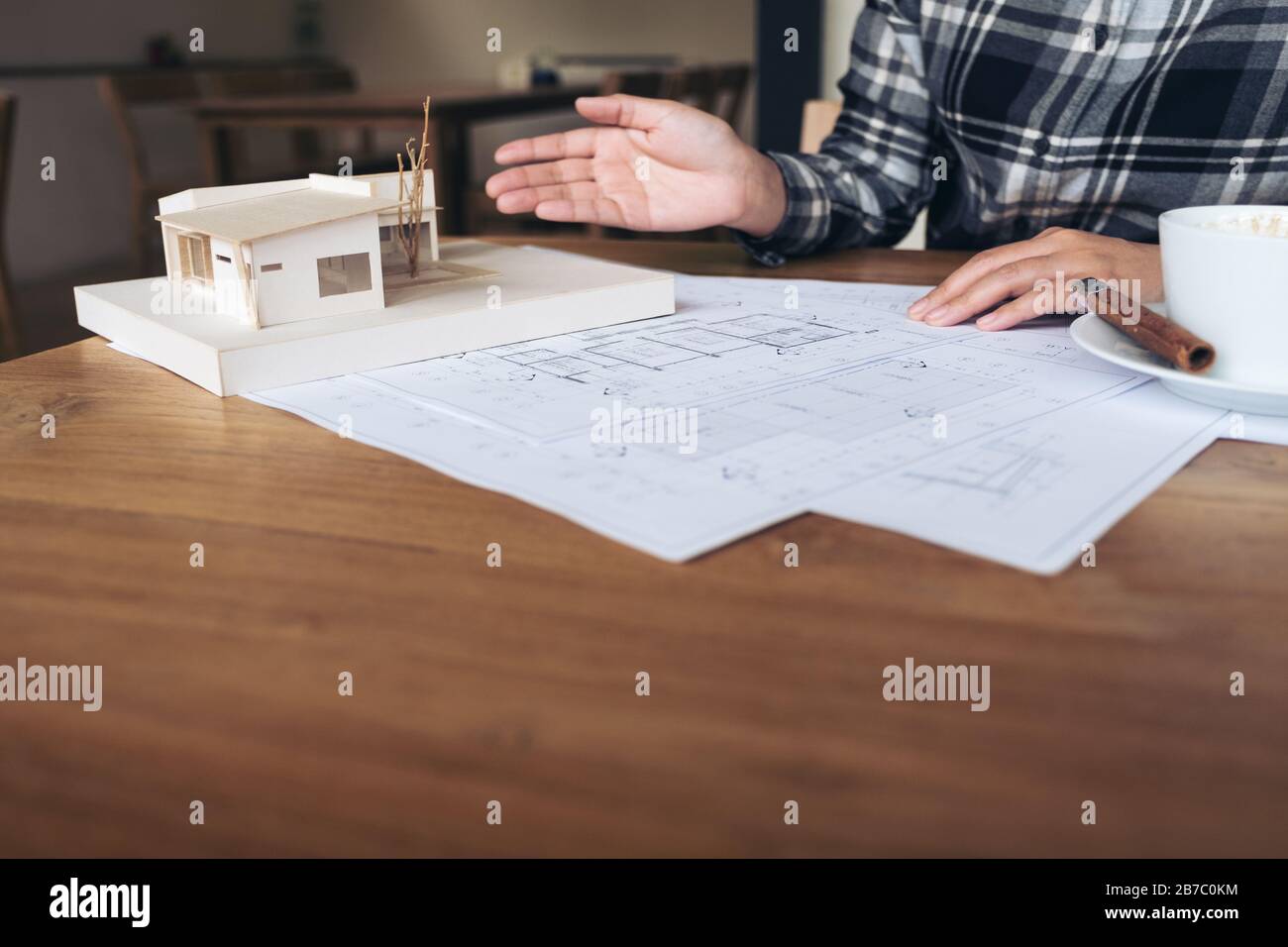 An architect working on an architecture model with shop drawing paper ...