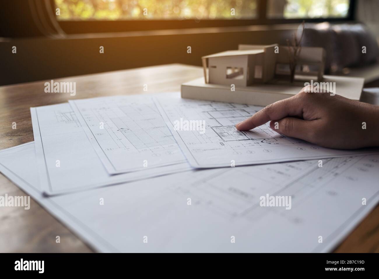 An architect working on an architecture model with shop drawing paper ...