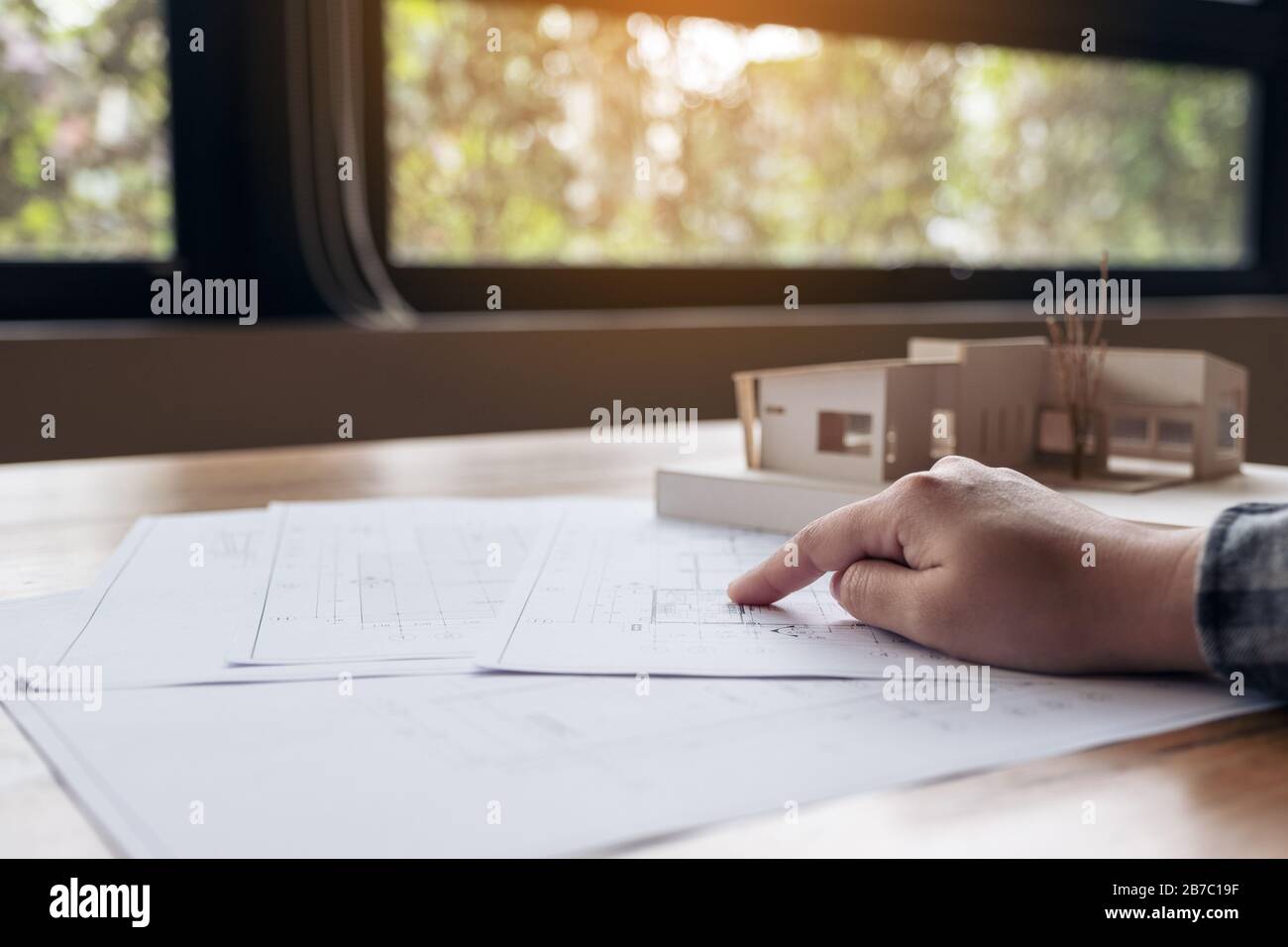 An architect working on an architecture model with shop drawing paper ...