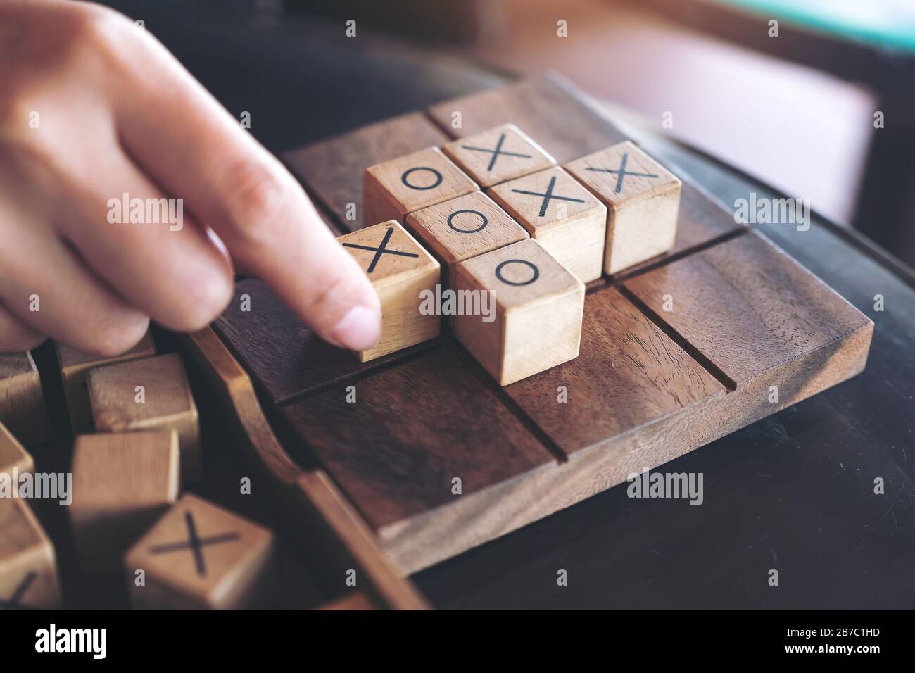 Closeup image of people playing wooden Tic Tac Toe game or OX game ...