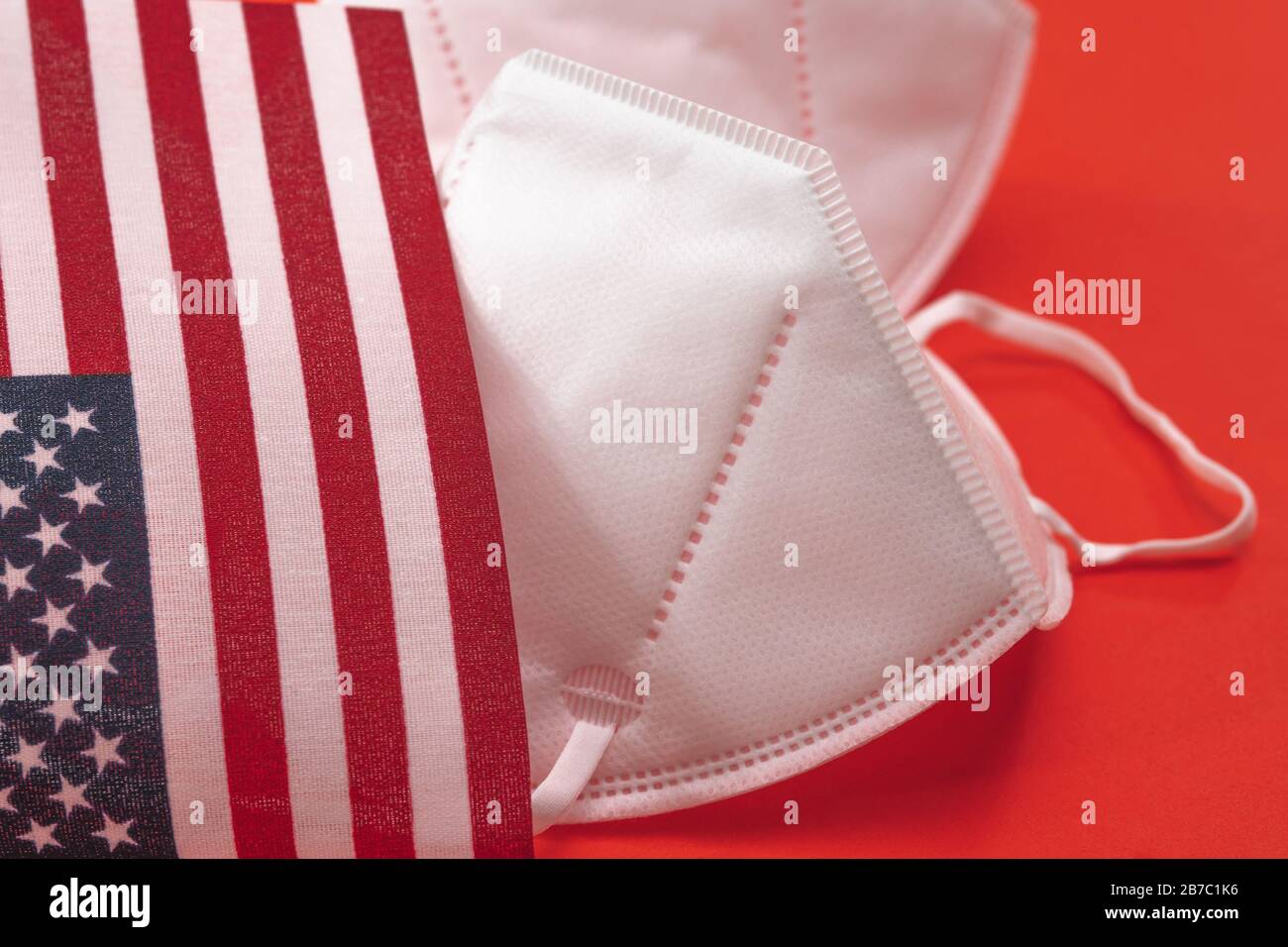 American flag and medical protective masks close up on red background ...