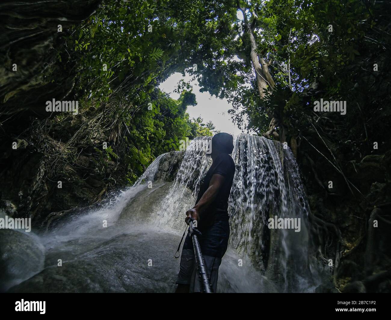 A man taking a selfie using an action camera in Aguinid waterfalls of ...