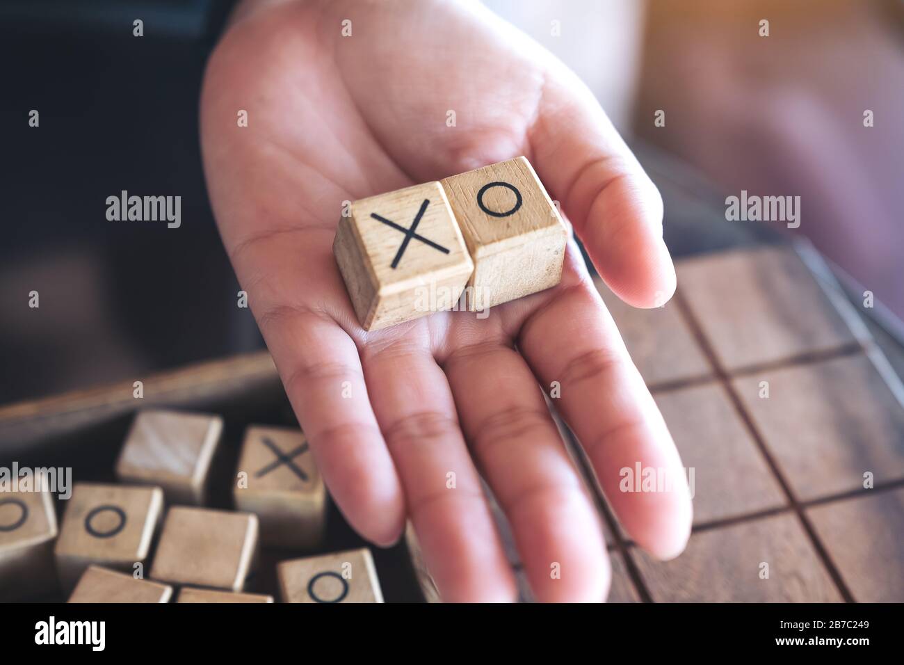 Closeup image of people holding wooden Tic Tac Toe game or OX game ...