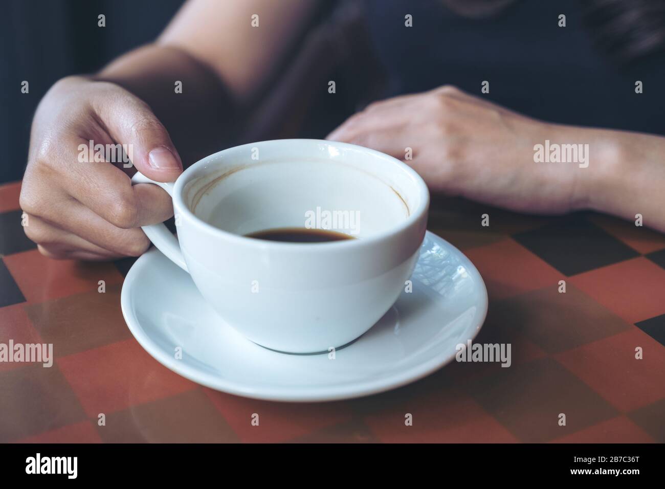 Closeup image of a hand holding and drinking hot coffee in cafe Stock ...