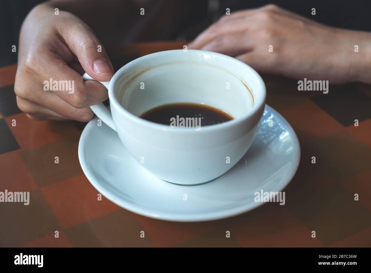 Closeup image of a hand holding and drinking hot coffee in cafe Stock ...