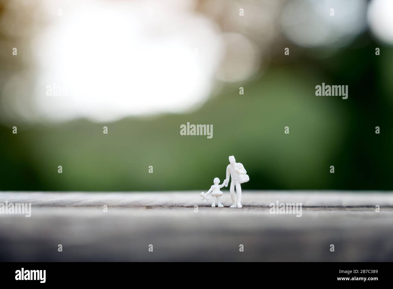 Closeup image of miniature figure model of father and daughter walking ...