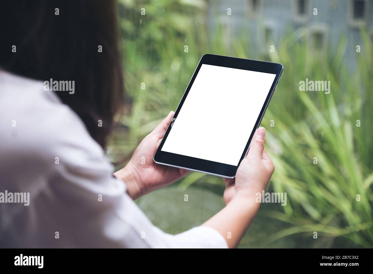 Mockup image of woman's hands holding black tablet pc with blank white ...